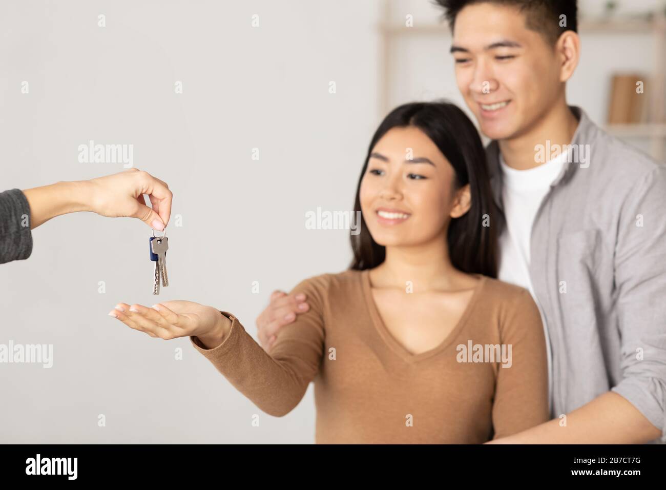 Asian man and woman receiving key from their flat Stock Photo - Alamy