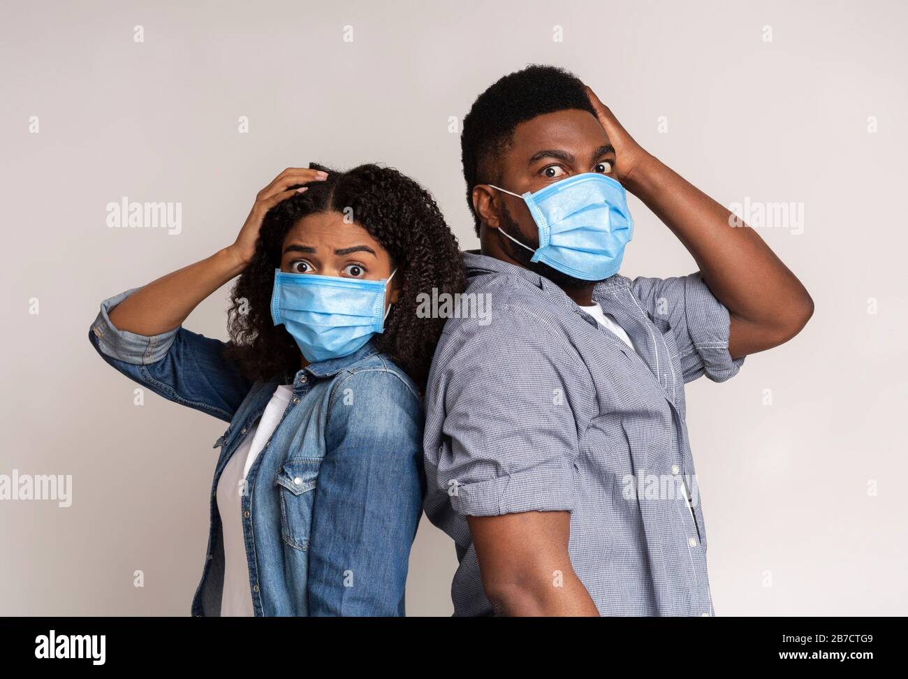 Afraid Black Couple Wearing Protective Masks And Holding Head With Hand ...