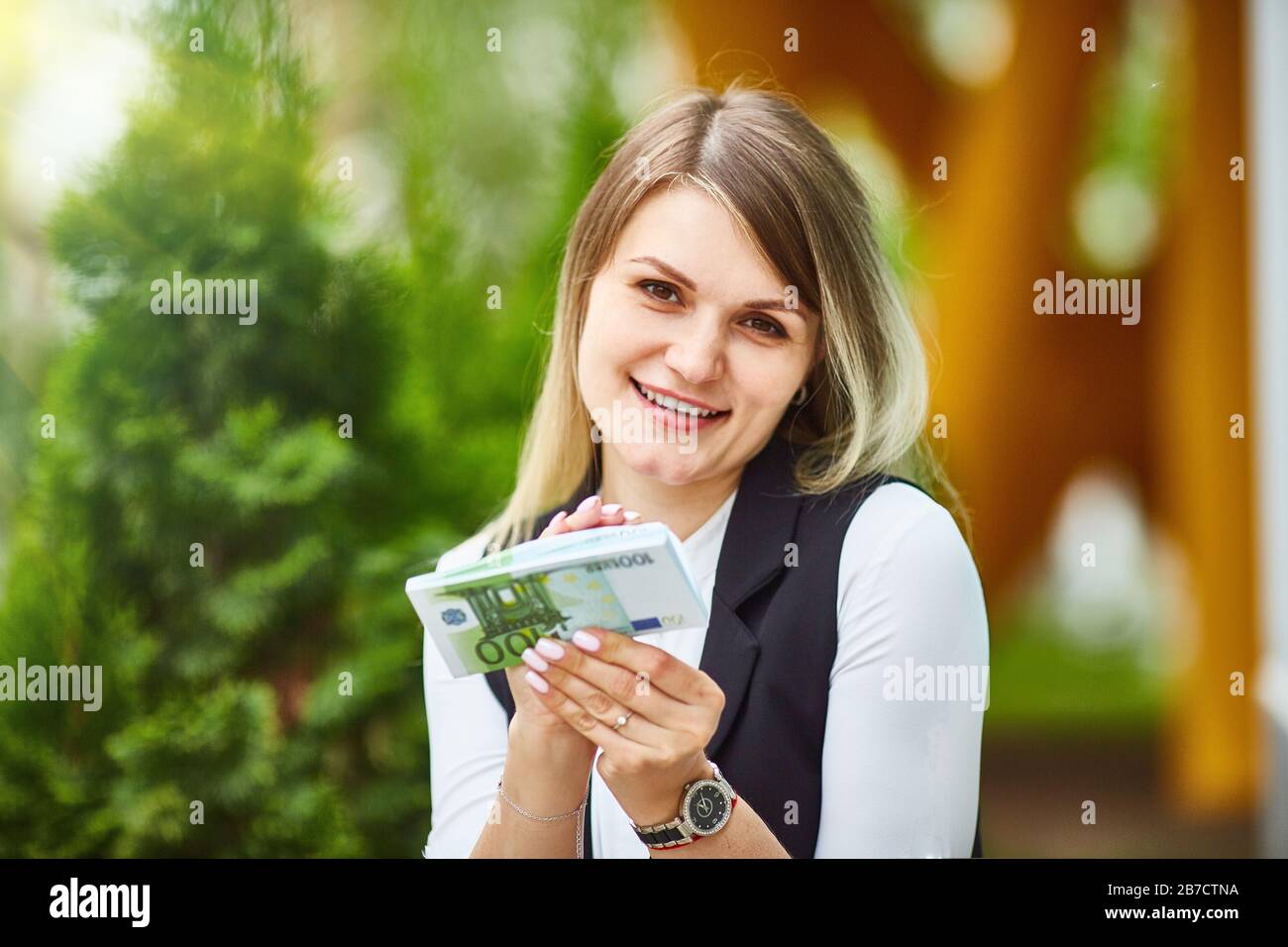 Happy girl holding a stack of euro banknotes and smiling. Business ...
