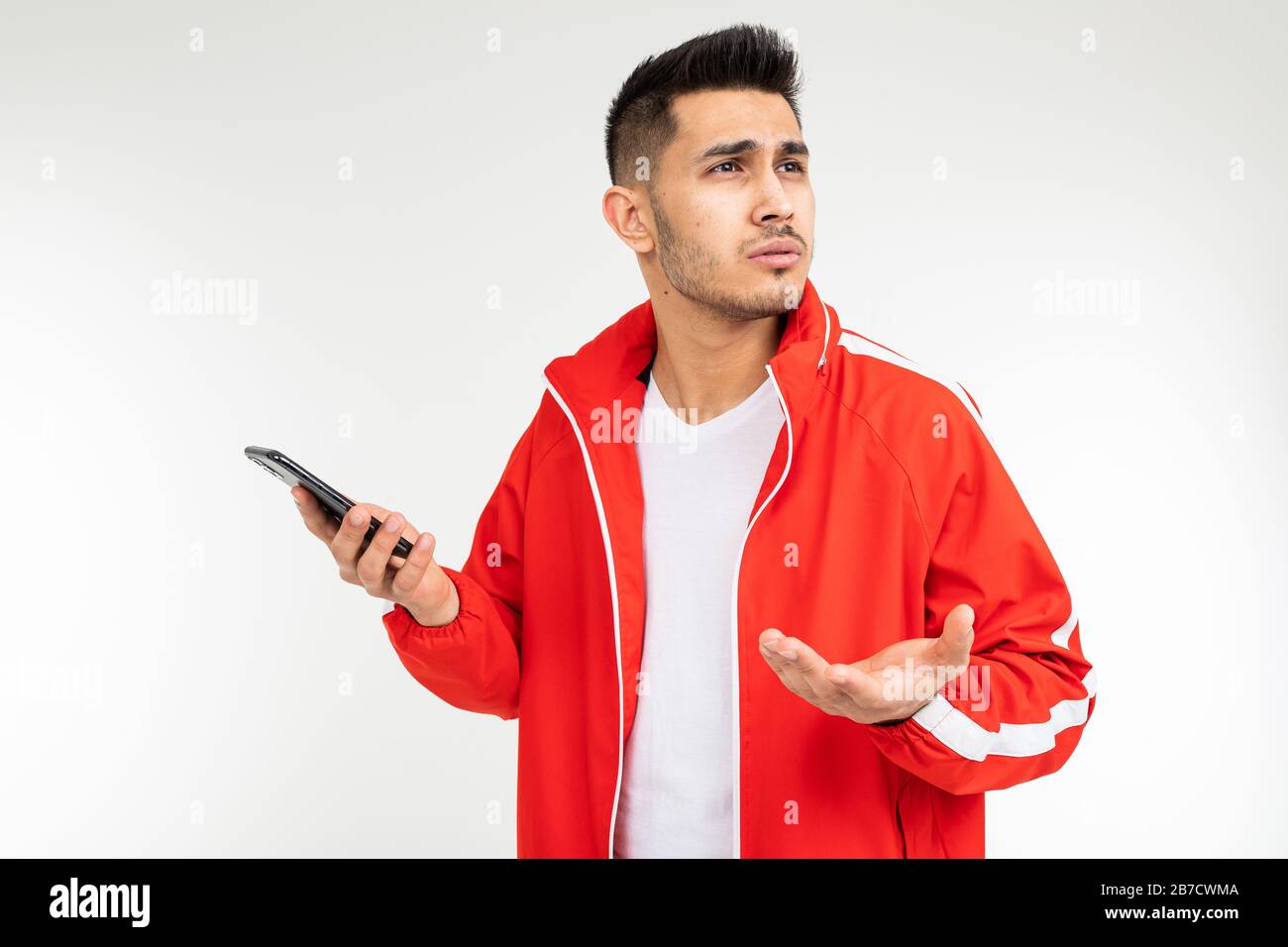 portrait of a handsome stylish guy in a red trowel talking on a telopn ...