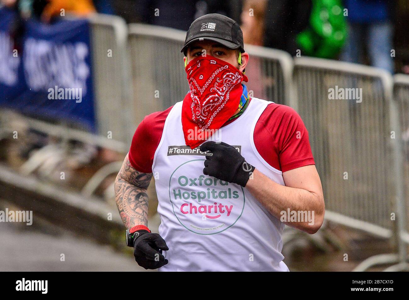 A runner covers his face during the Bath Half Marathon as they run ...