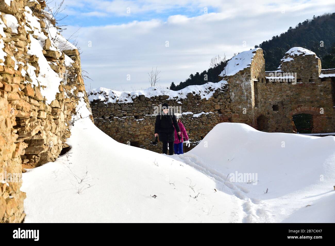 Tourist hiking in the ruins castle on the snow in Slovakia Zborov ruins ...