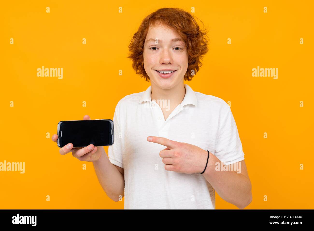 Caucasian guy in a white shirt with a smartphone with a blank template ...