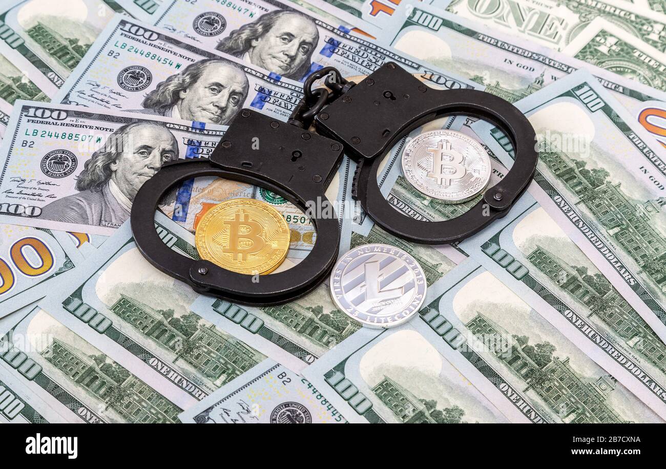 Steel police handcuffs and coins of cryptocurrency lying on the ...