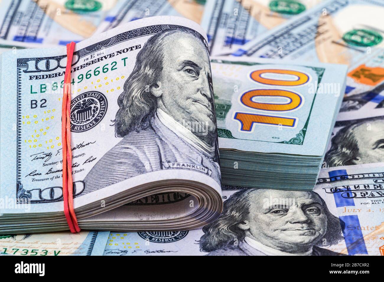 Folded dollar bills wrapped by rubber band over dollars banknotes Stock ...