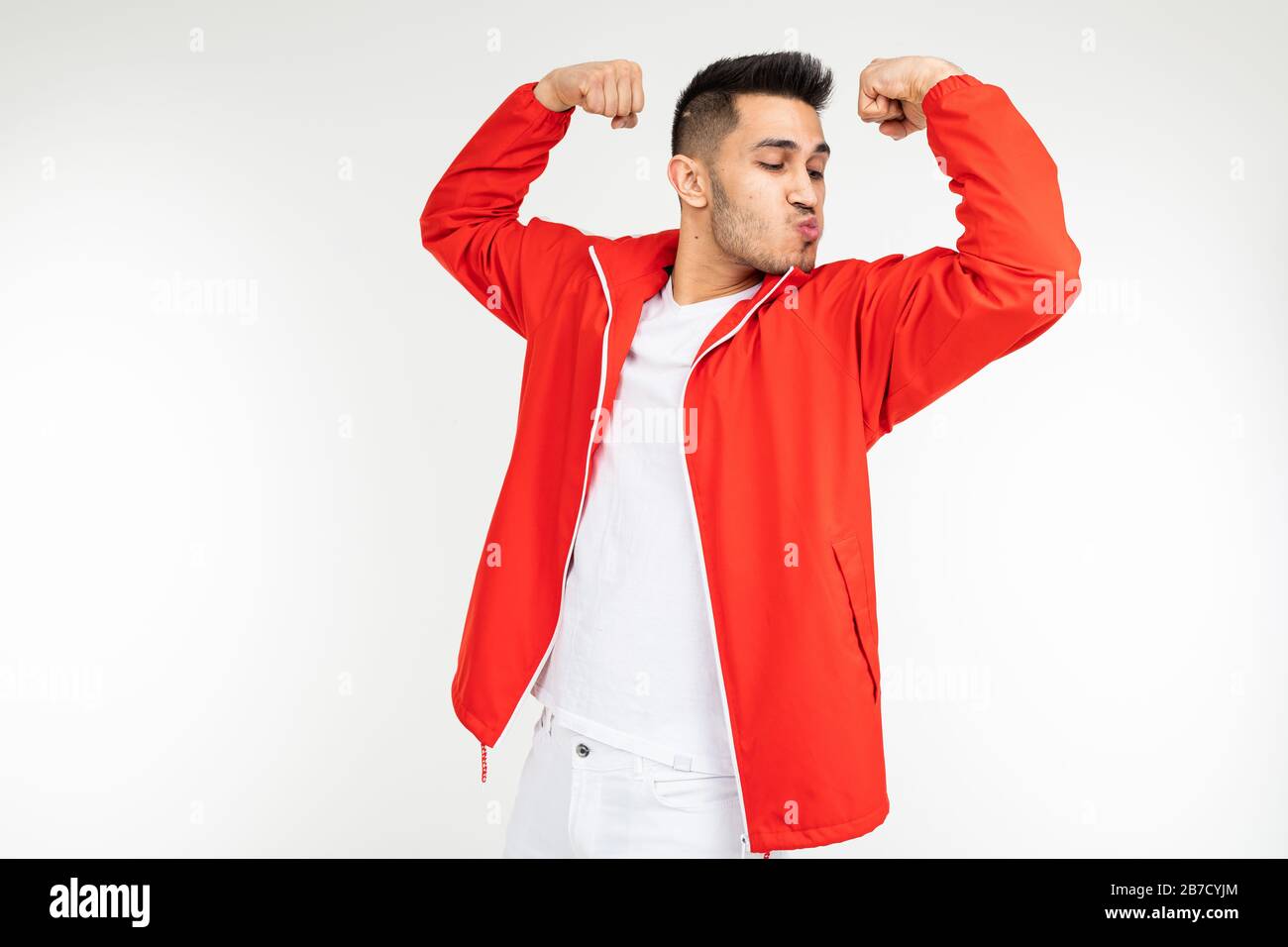 strong man in sports red shows his muscles on a white background with ...