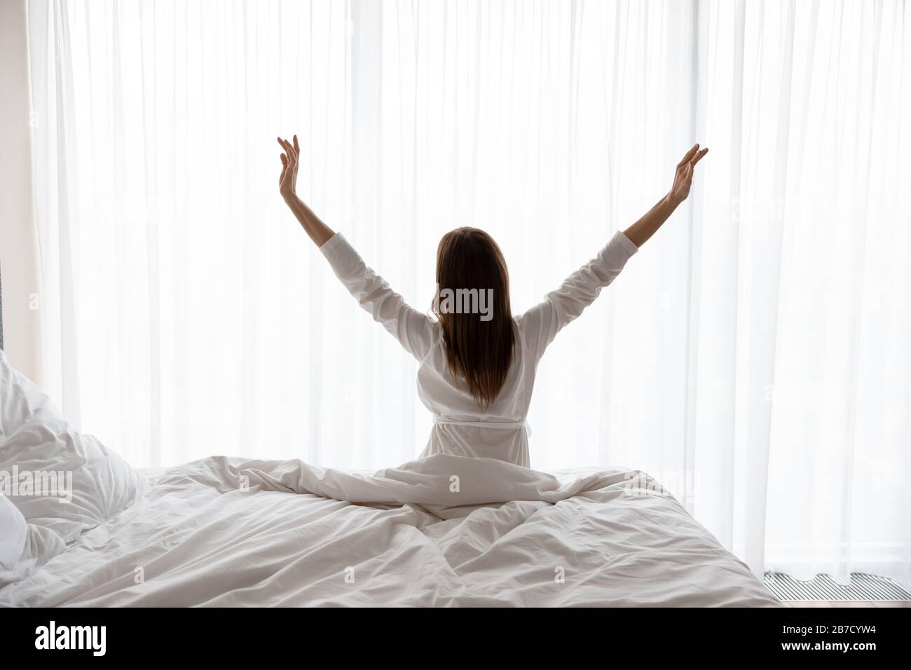 Rear back view young brunette woman stretching muscles Stock Photo - Alamy