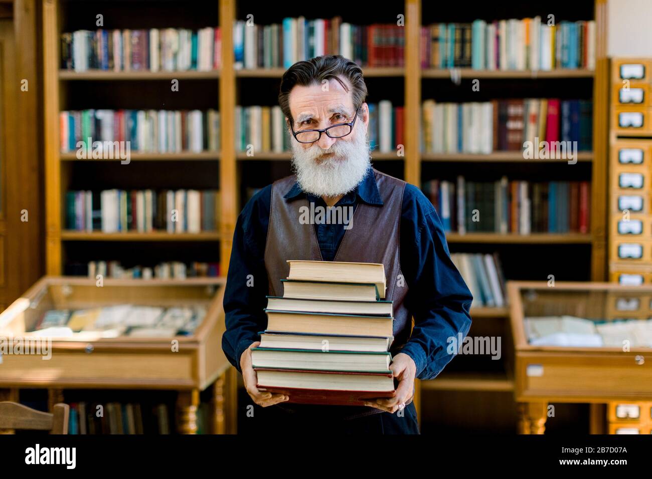 Portrait of positive smart old bearded man in dark shirt and leather ...