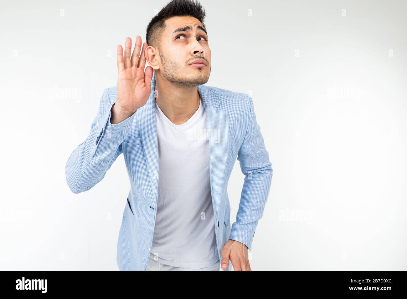 young guy in a blue jacket overhears a conversation on a white ...