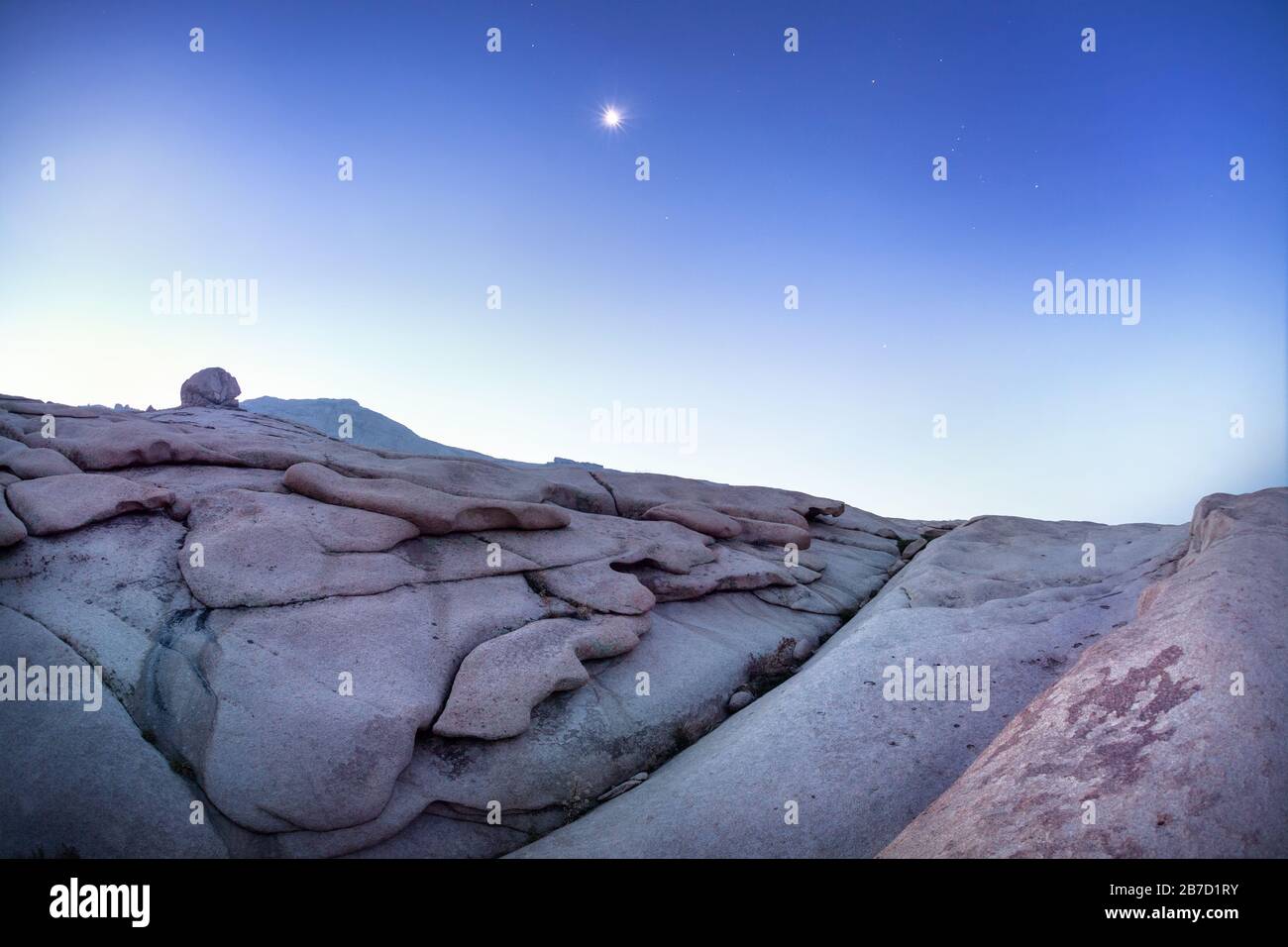 Extinct volcano stone formation at early morning with moon and stars in ...