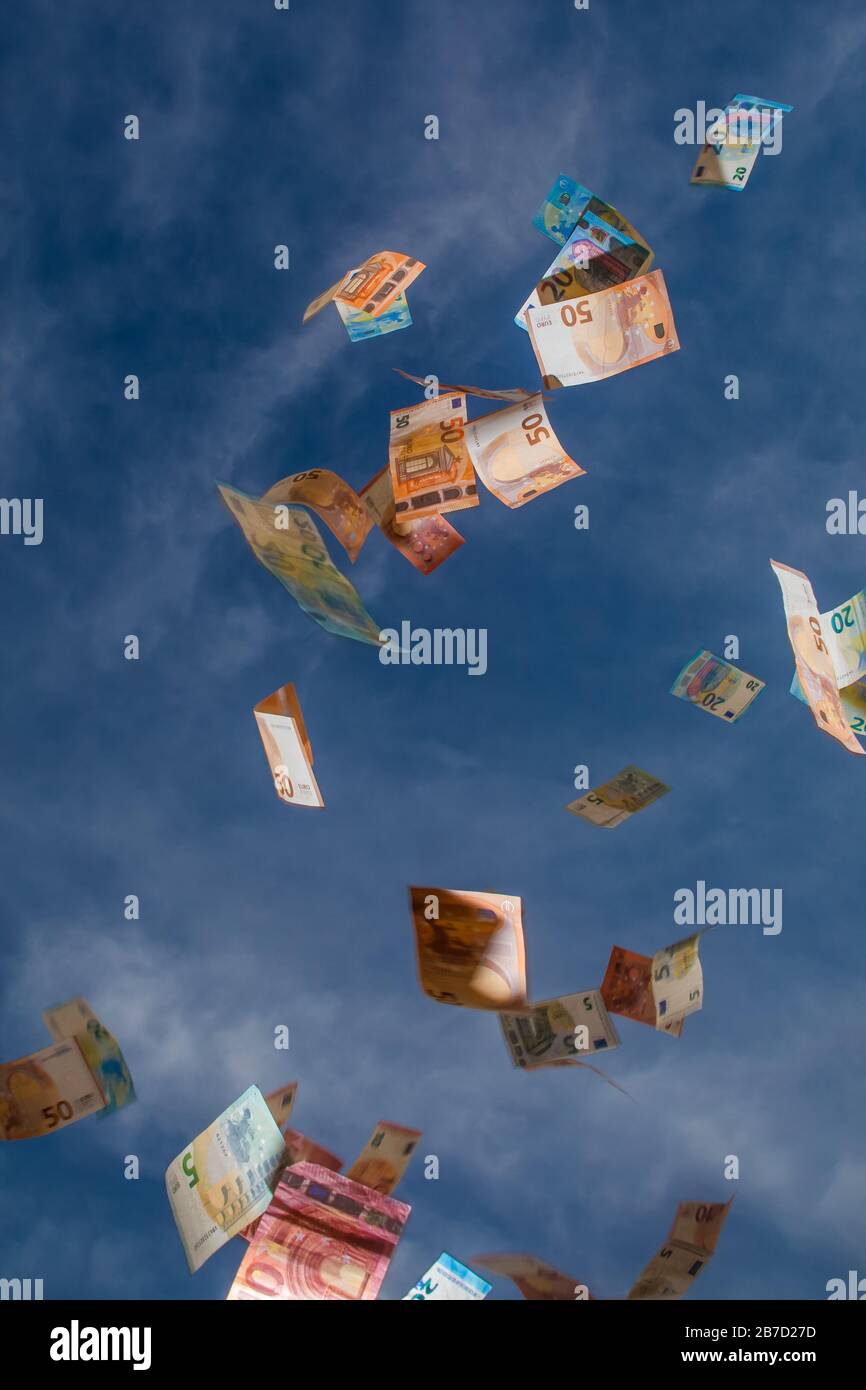 Falling money from the blue sky with clouds Stock Photo - Alamy