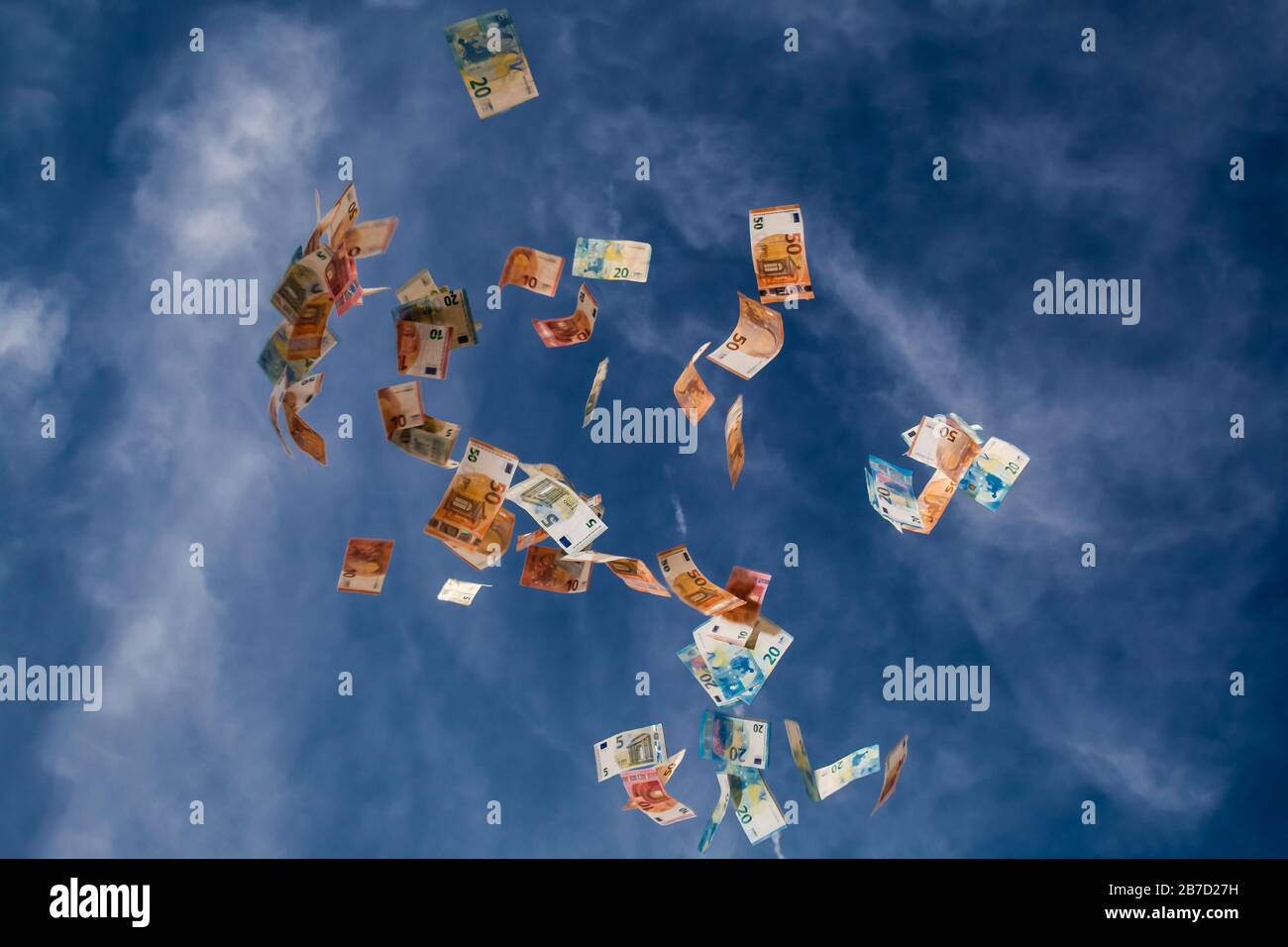 Falling money from the blue sky with clouds Stock Photo - Alamy