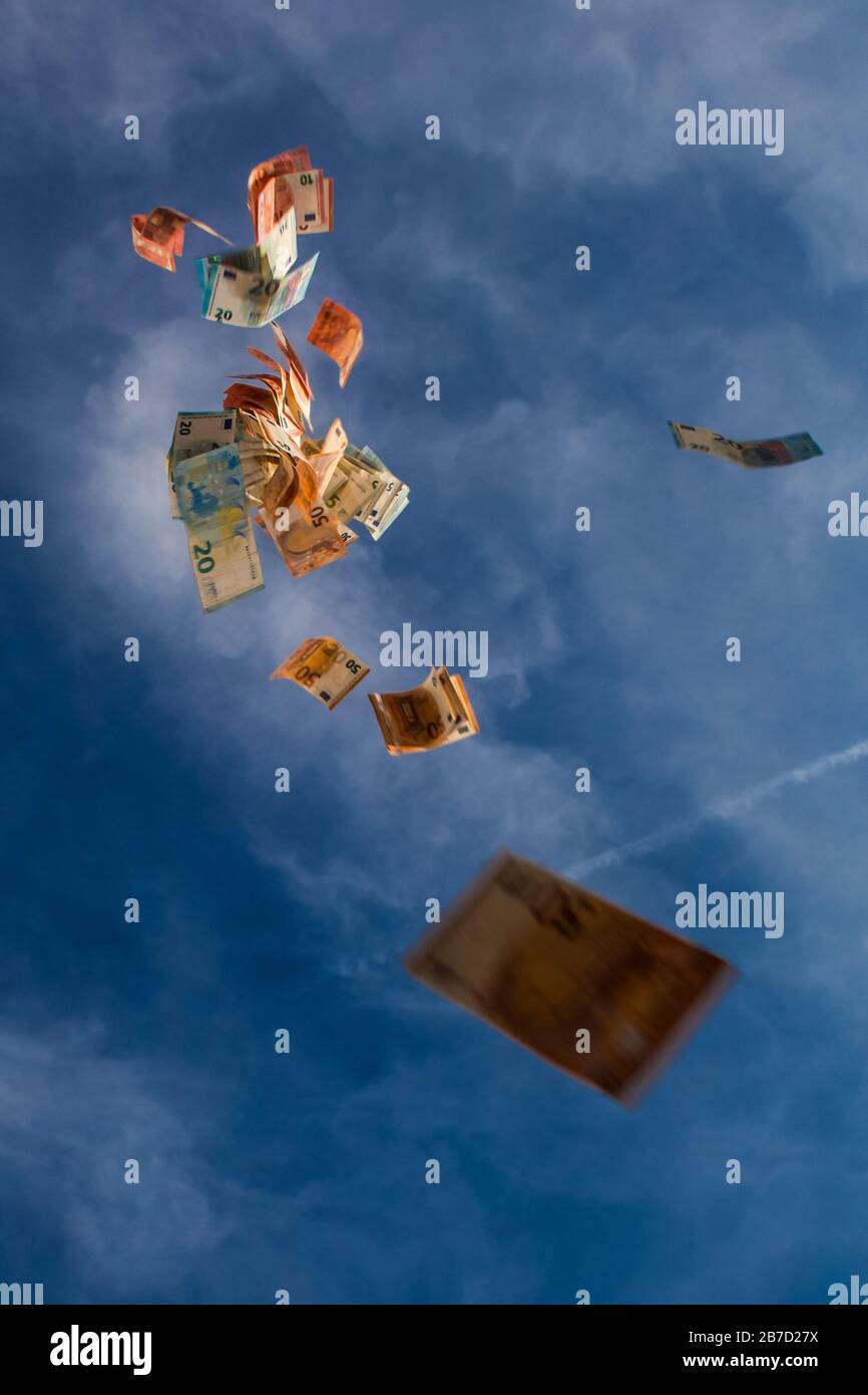 Falling money from the blue sky with clouds Stock Photo - Alamy