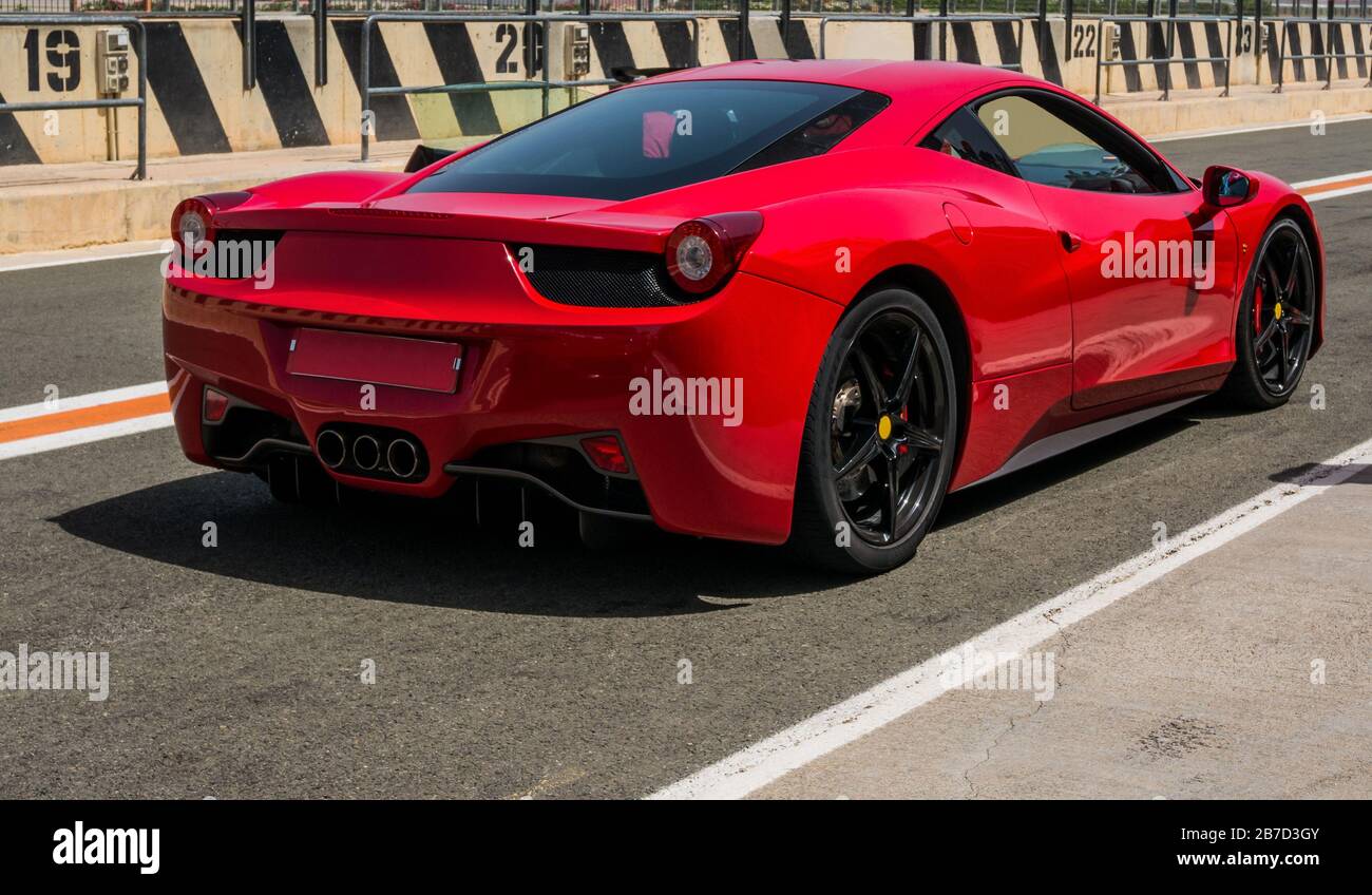 Rear view of red sport car in race circuit Stock Photo - Alamy
