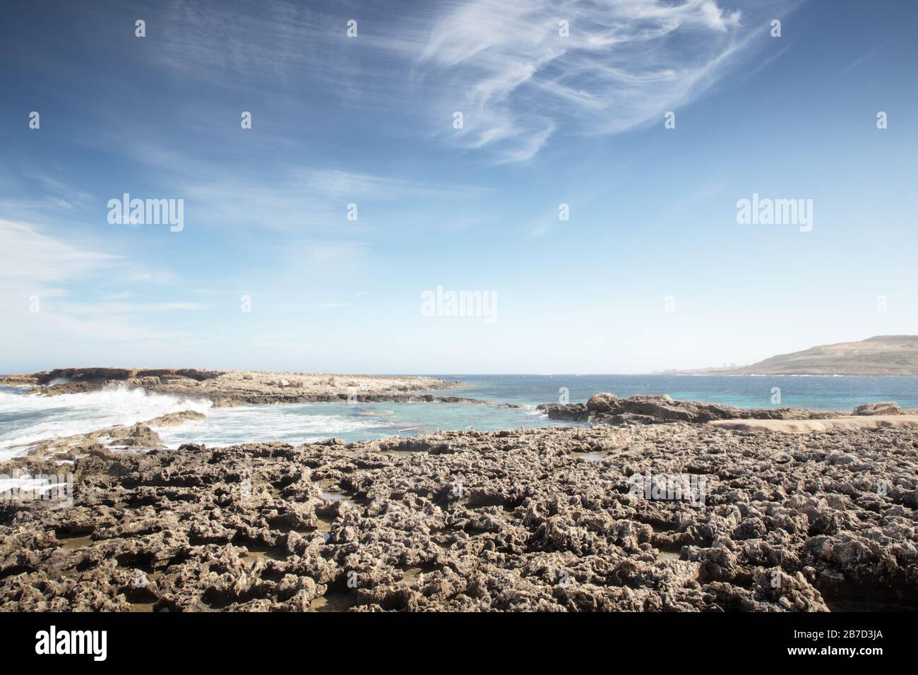 rocky beach in Qawra Point Beach in the background a plot of land was ...