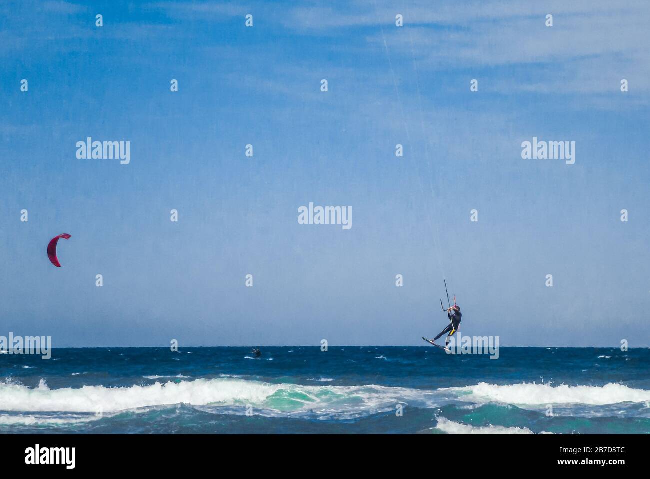 Kite surf jump at the beach with blue sky and waves Stock Photo - Alamy