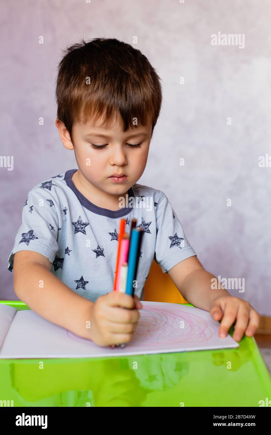 Little boy drawing with color pencils. Little boy is holding color ...