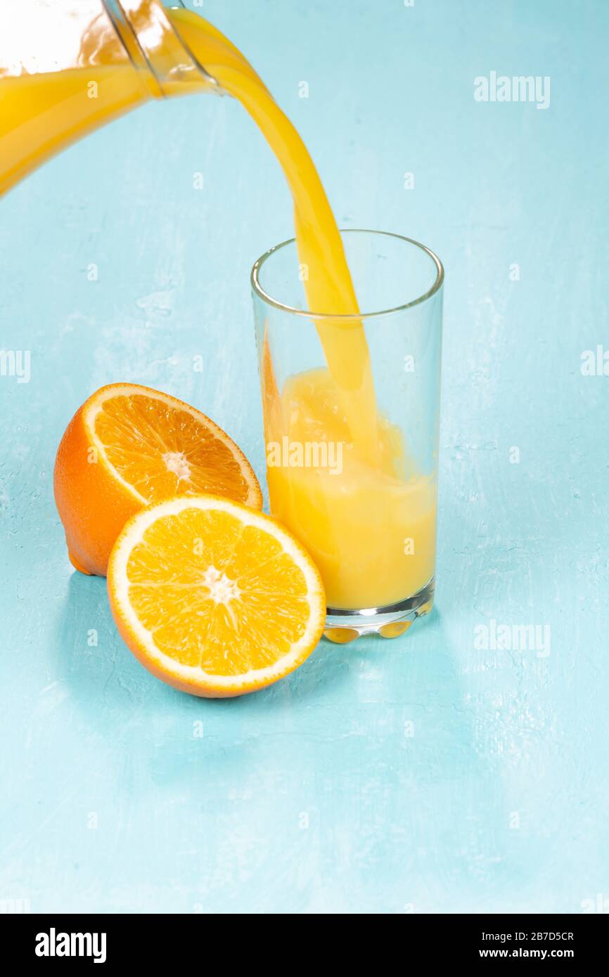 Fresh orange juice is poured into a glass Stock Photo - Alamy