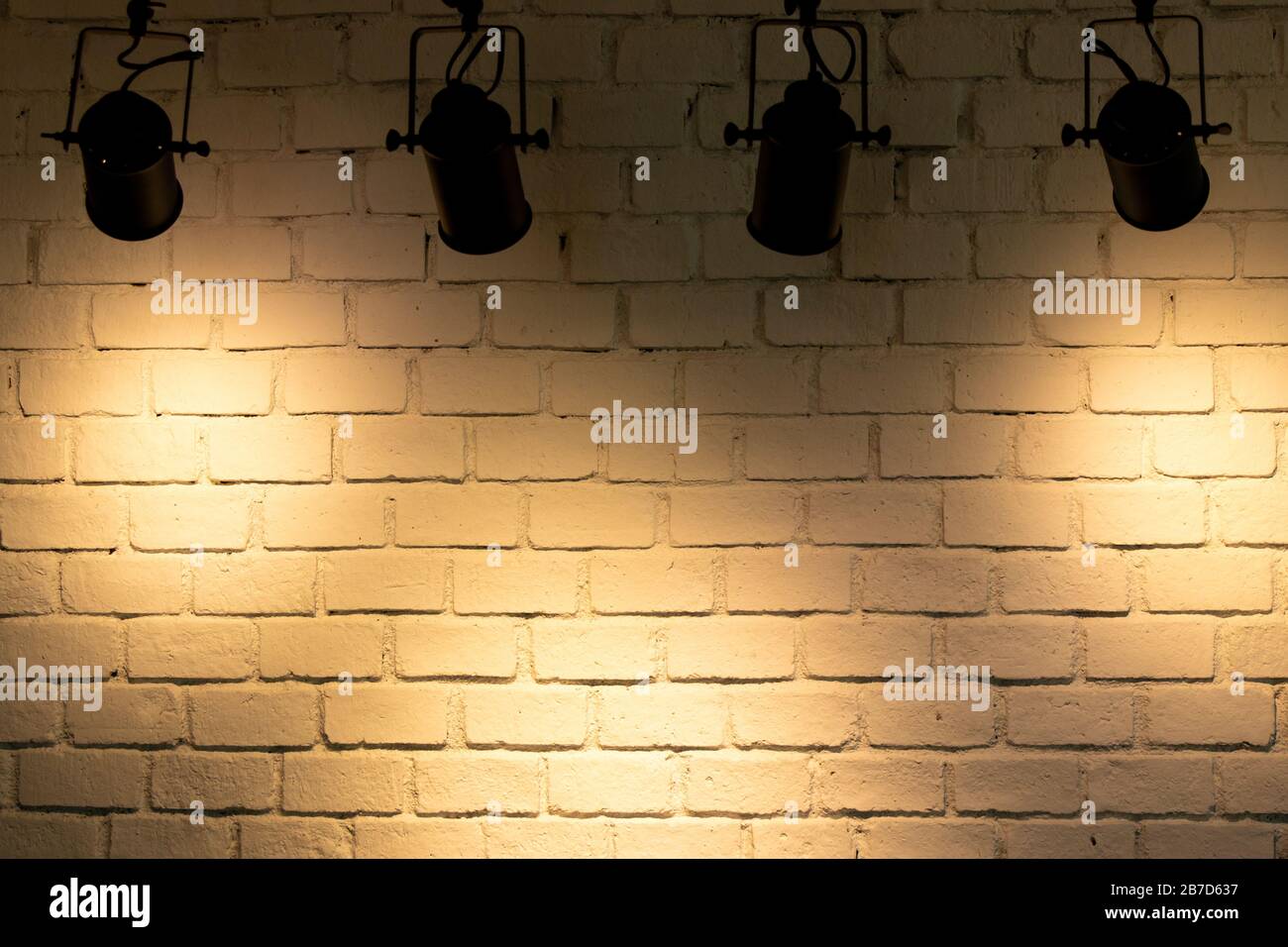 Hanging spotlight illuminate at brick wall background with copy space ...