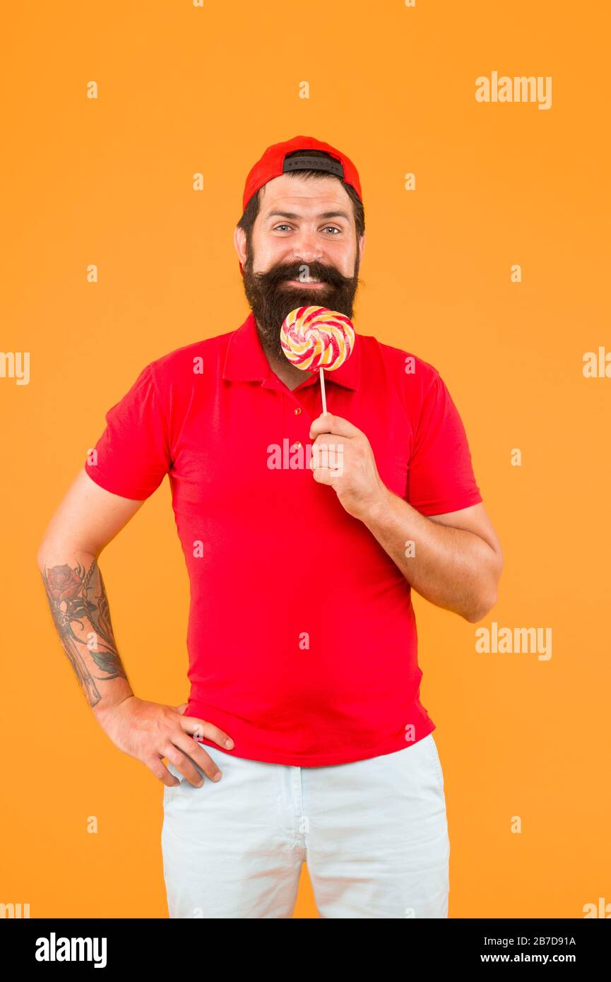 Keep licking. Sweet taste. Happy hipster eat lollipop candy. Taste of ...