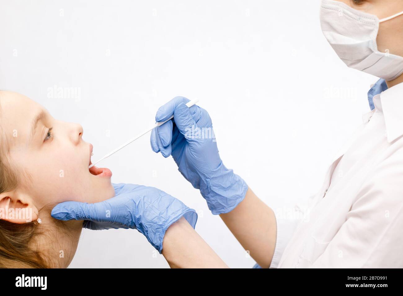 Pediatrician or doctor taking saliva test sample from elementary age ...