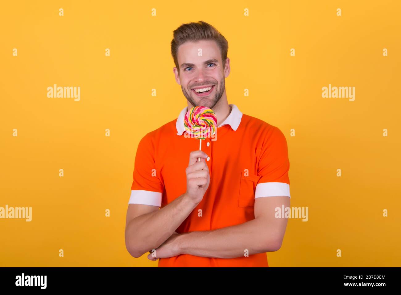 Sweet that speaks. Sweet tooth yellow background. Happy man hold candy ...