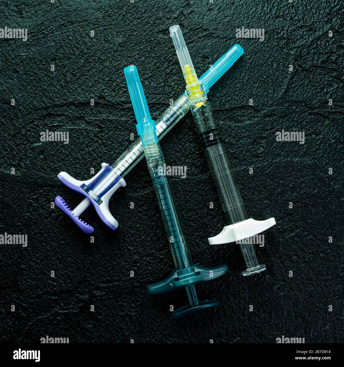 cosmetology injections. Plastic syringe on black background. Medical ...