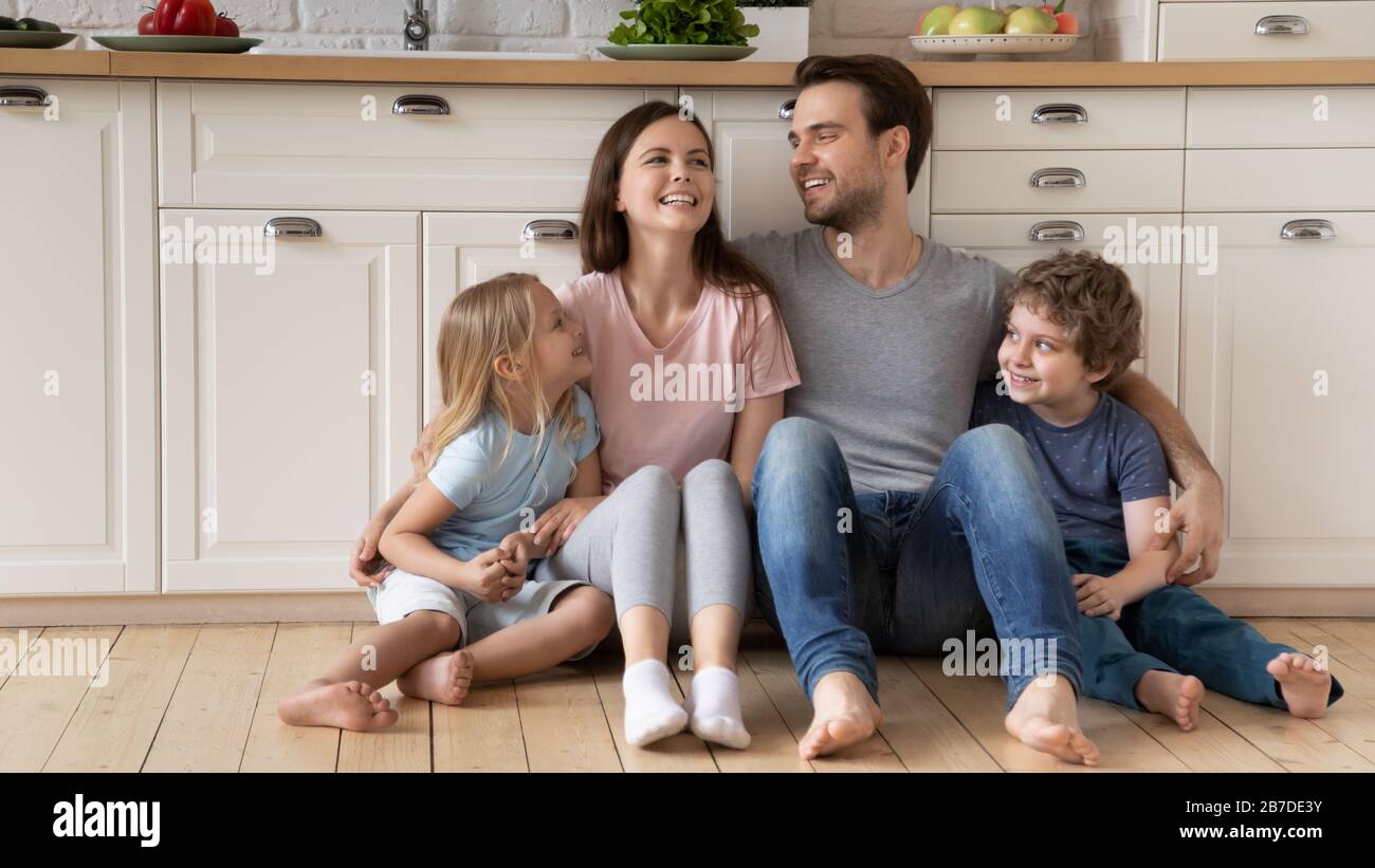 Happy parents with kids sit on floor relaxing Stock Photo - Alamy