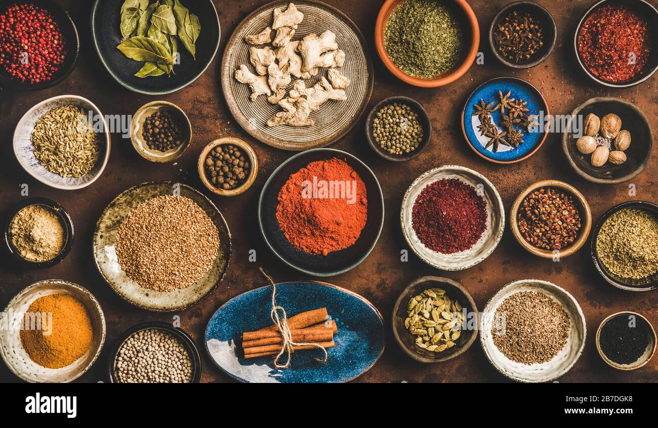 Flat-lay of spices in bowls and plates over rusty background, top view ...