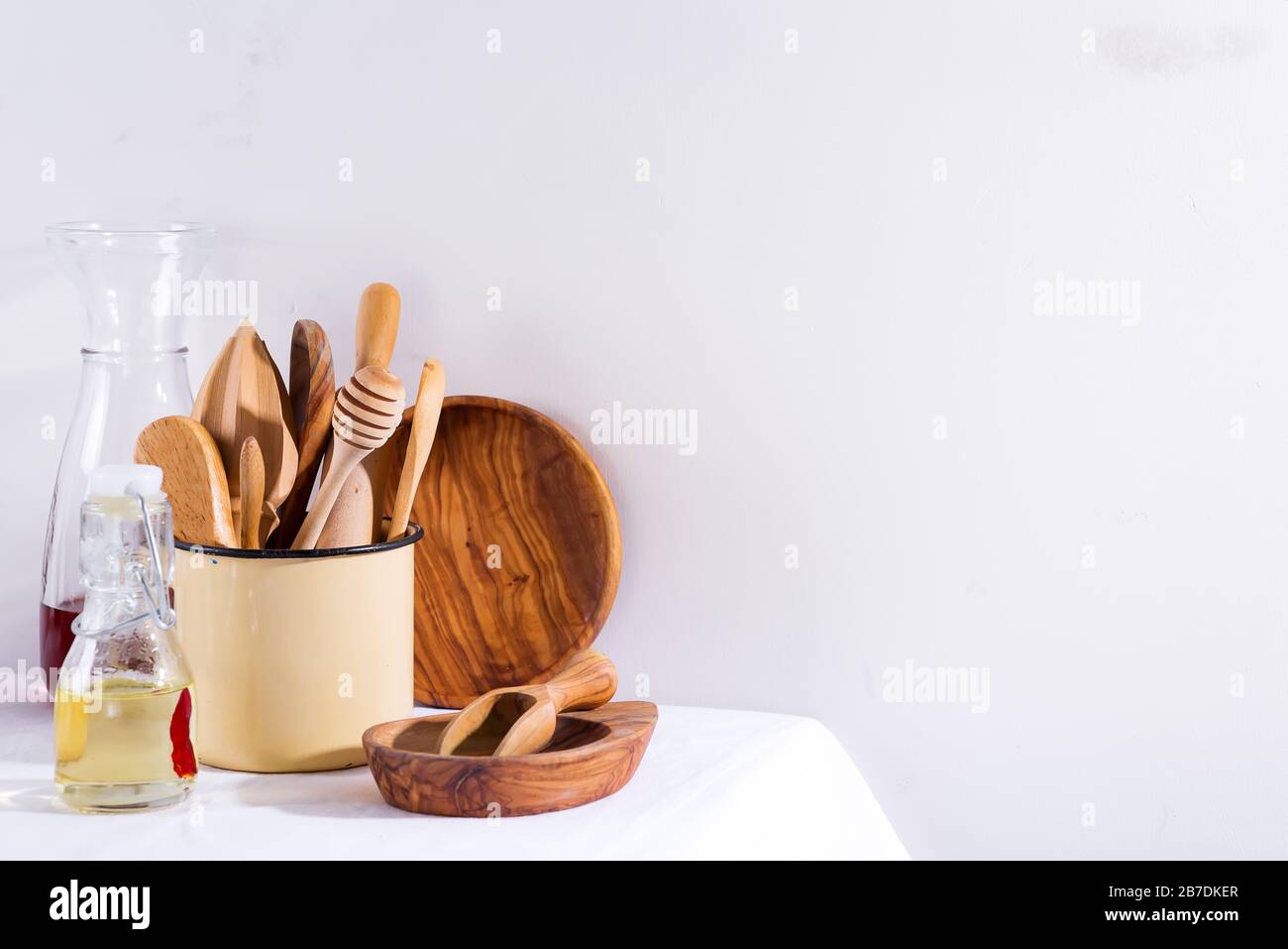 Wooden set of kitchenware in iron cup with wooden plates on white ...