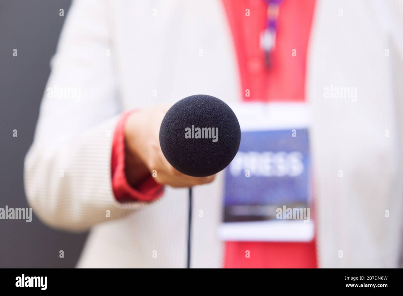 Female reporter holding microphone during media interview. Journalism ...