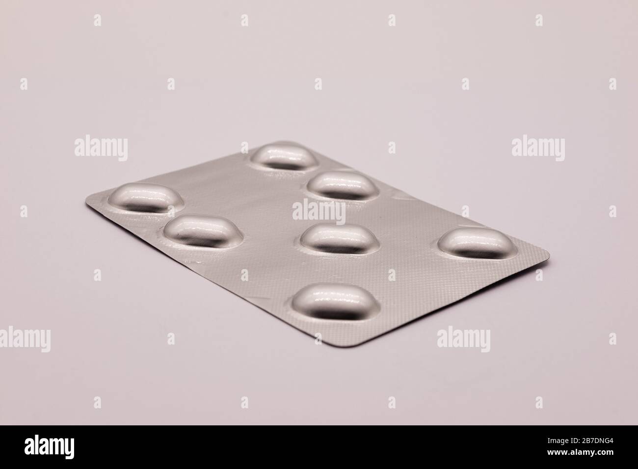 Generic Sleeve or Blister pack of Medical tablets lying on a white ...