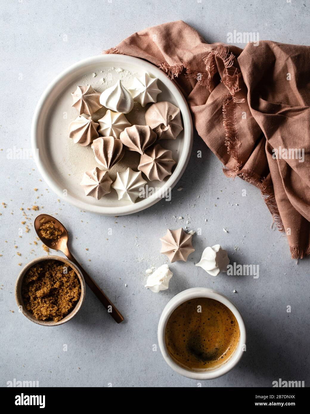 Chocolate and vanilla meringue puffs on a white dish with hot chocolate ...