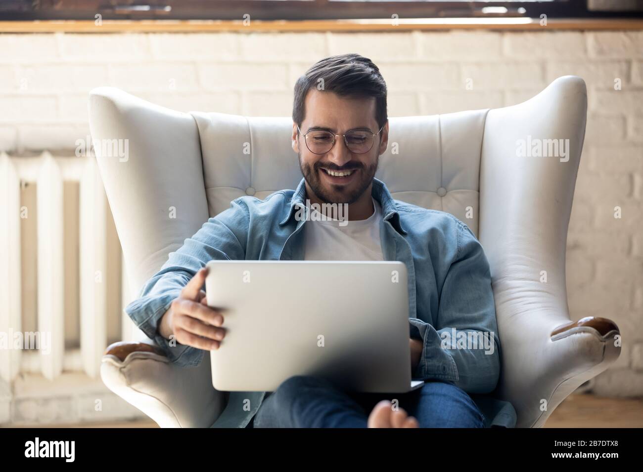 Positive young man using laptop hi-res stock photography and images - Alamy