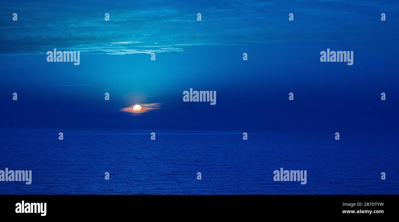 blue sky with a stunning sunset on the horizon right on the ocean Stock ...