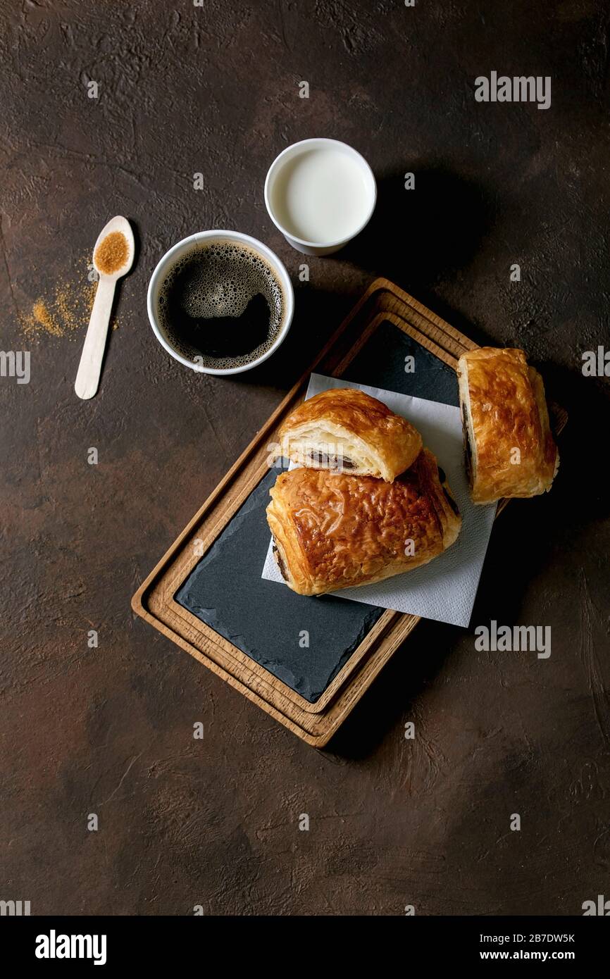 Traditional french puff pastry chocolate buns whole and slice on slate ...