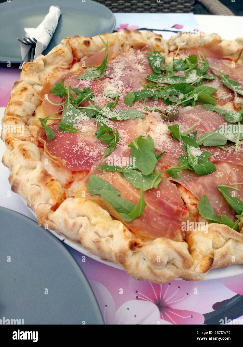 Stock image of pizza with ham on a table with two plates Stock Photo ...
