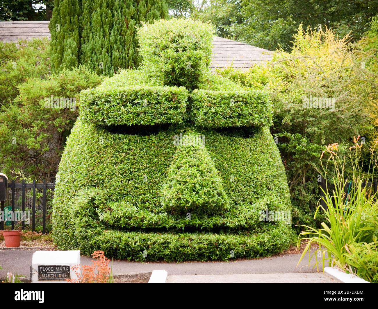 Topiary head trimmed into shrub the shape of an Easter Island face ...