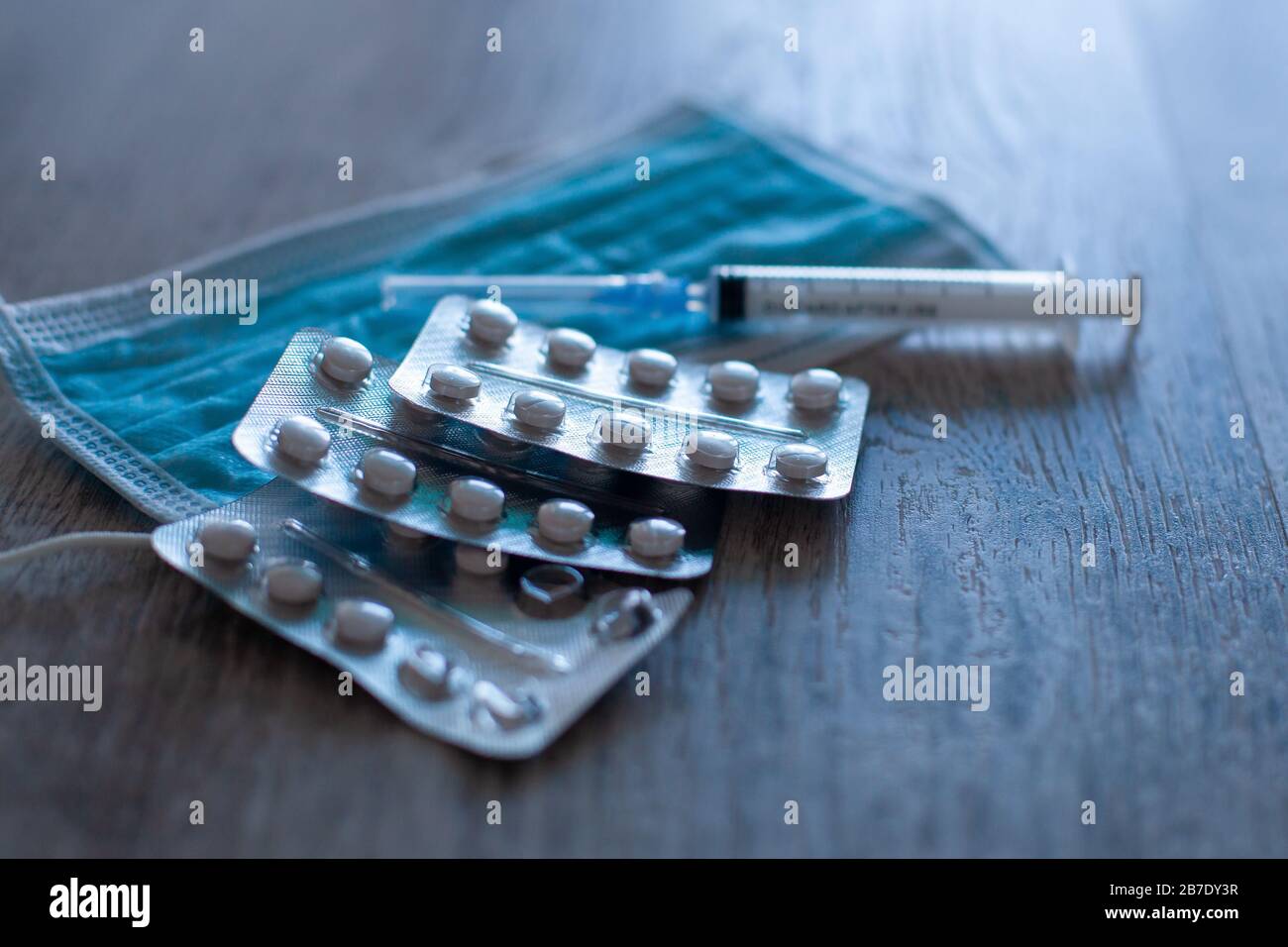 Medications in form of tablets, protective medical mask and syringe on ...
