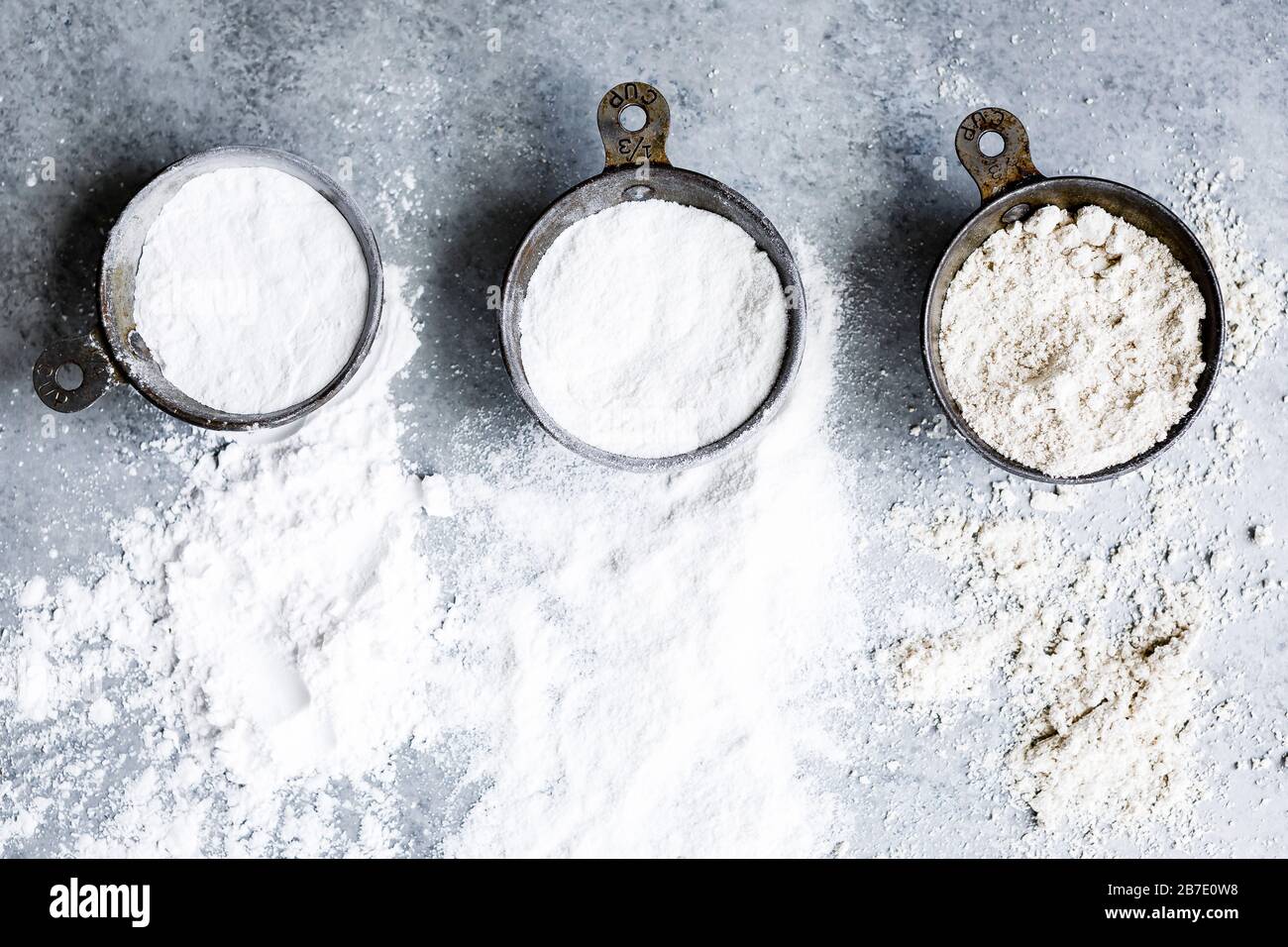 Three types of flour in measuring cups on a gray background Stock Photo ...
