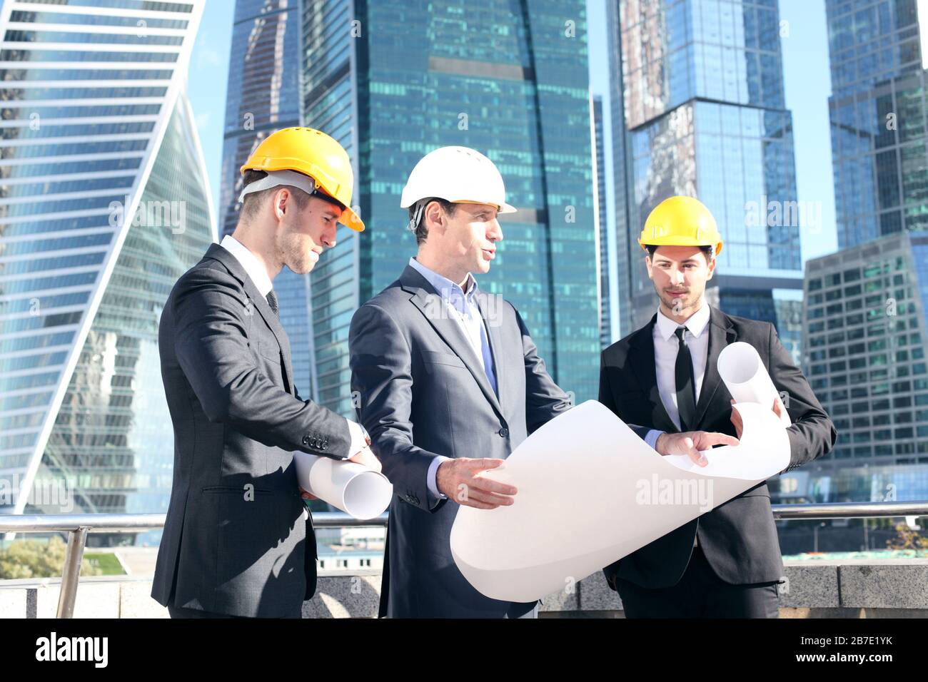 Team of architects comparing housing project with the building over ...