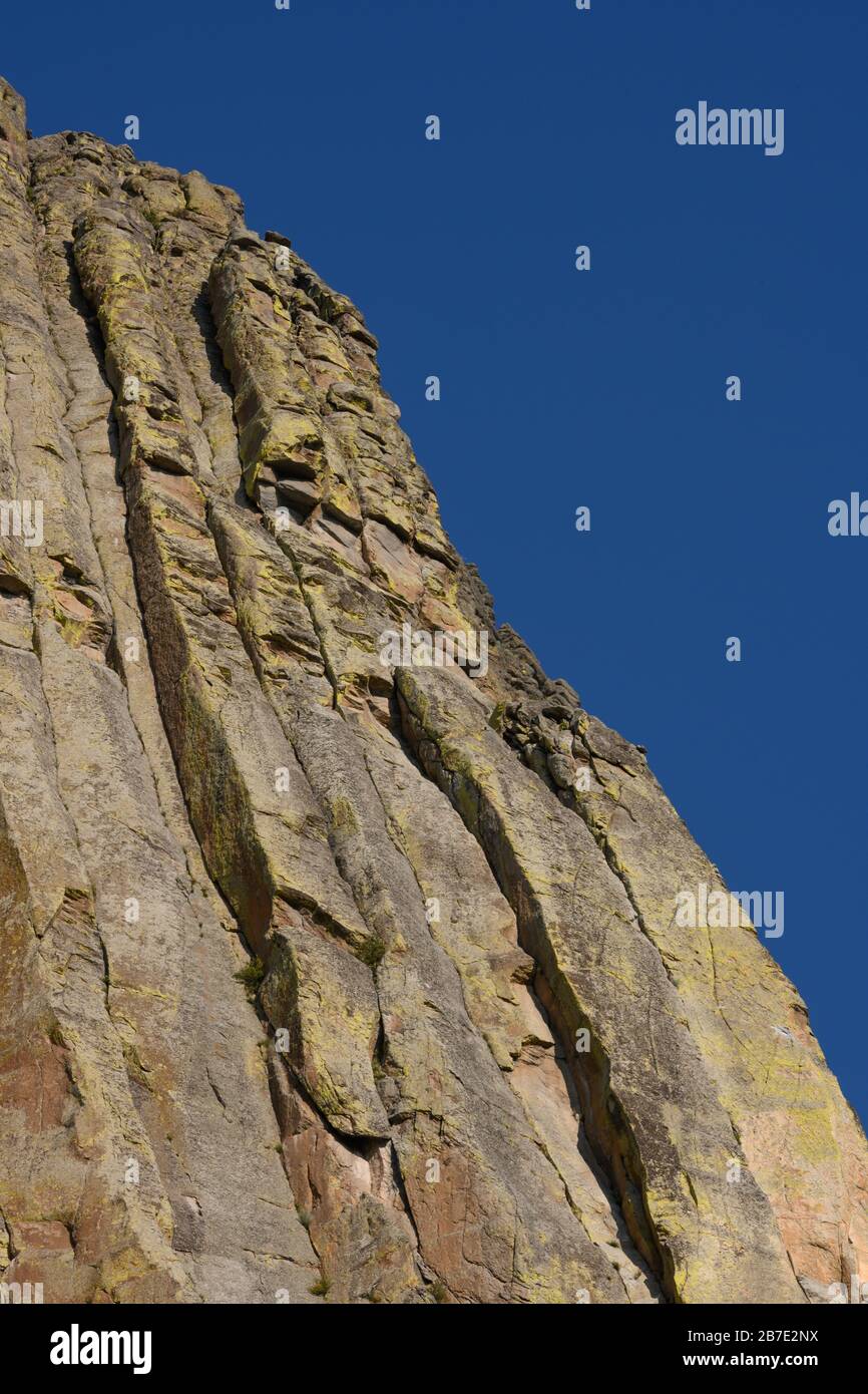 Edge of Devils Tower Monument with Blue Sky to right Stock Photo - Alamy