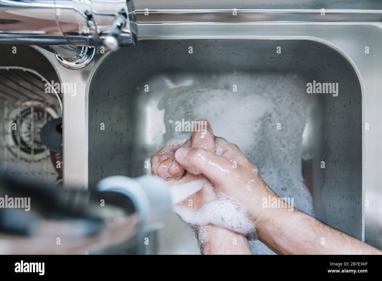 top view of two hands of a man taking off the soap with water in a ...
