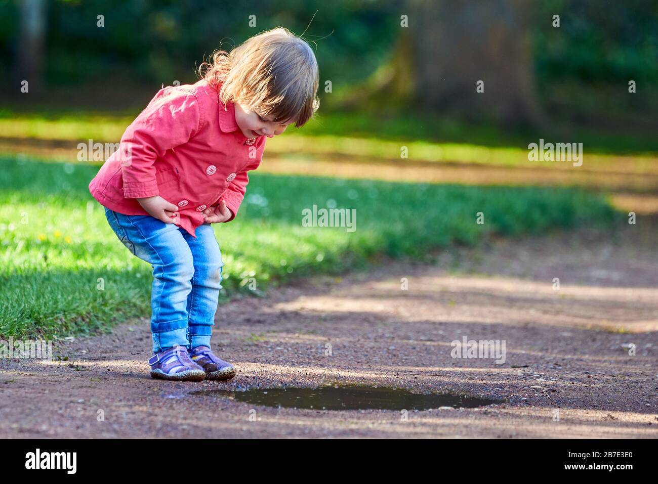 Little girl playing in a puddle Stock Photo - Alamy