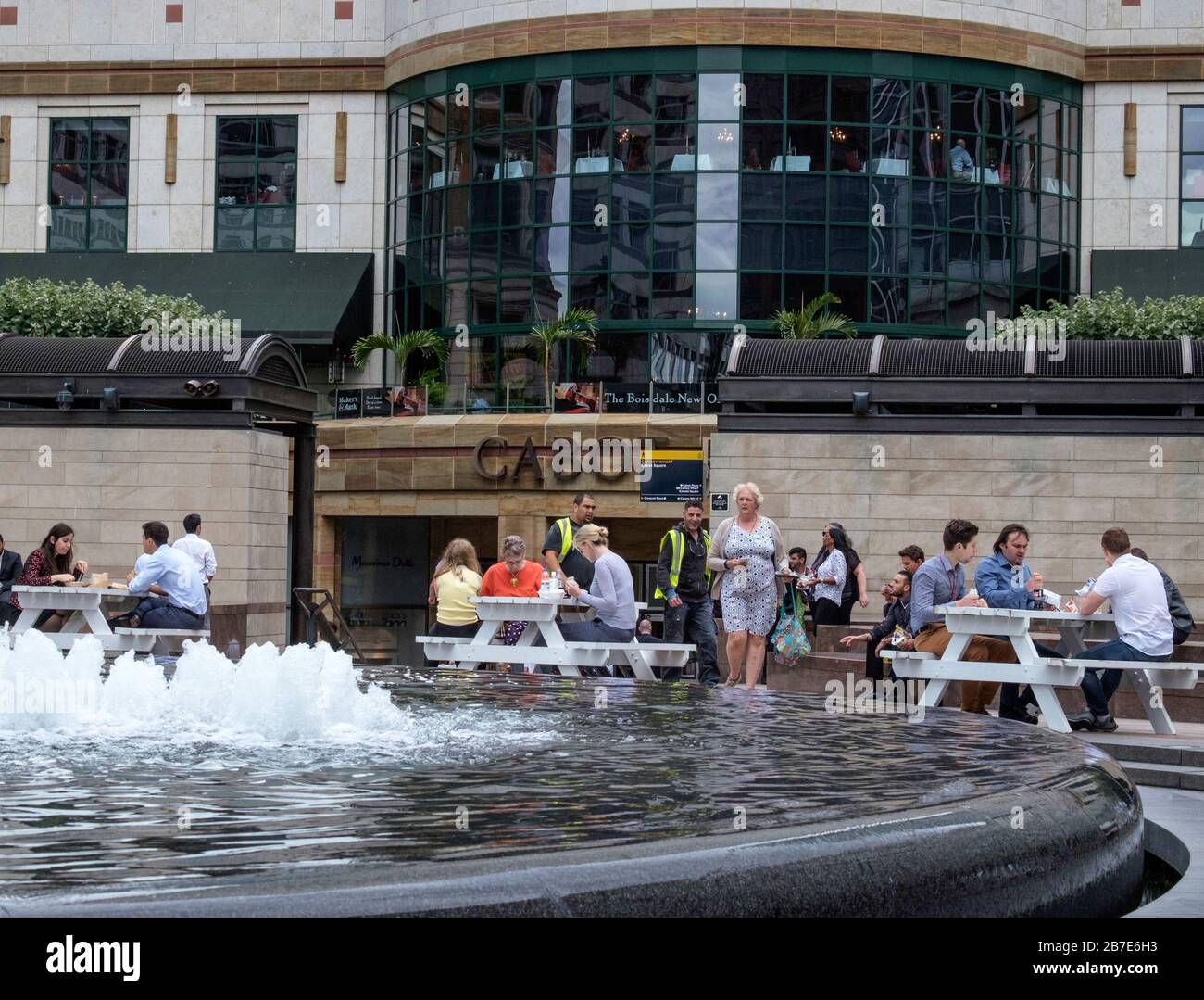 London office workers eat lunch at outside tables next to the fountain ...