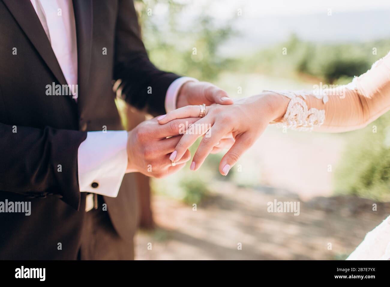 Wedding rings in the hands of the bride and groom Stock Photo - Alamy