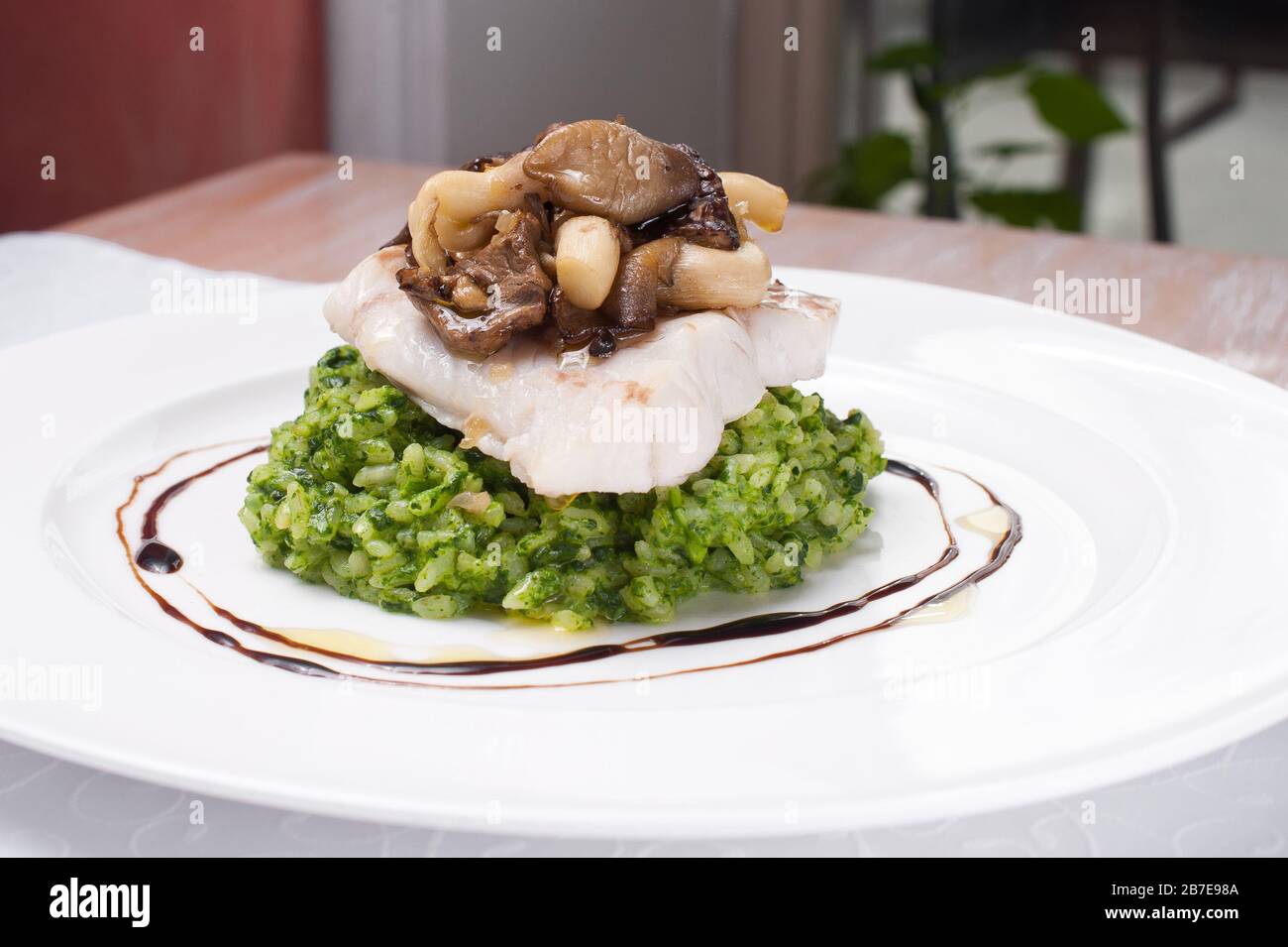 Fine dining, fish fillet on risotto with spinach and mushrooms Stock ...