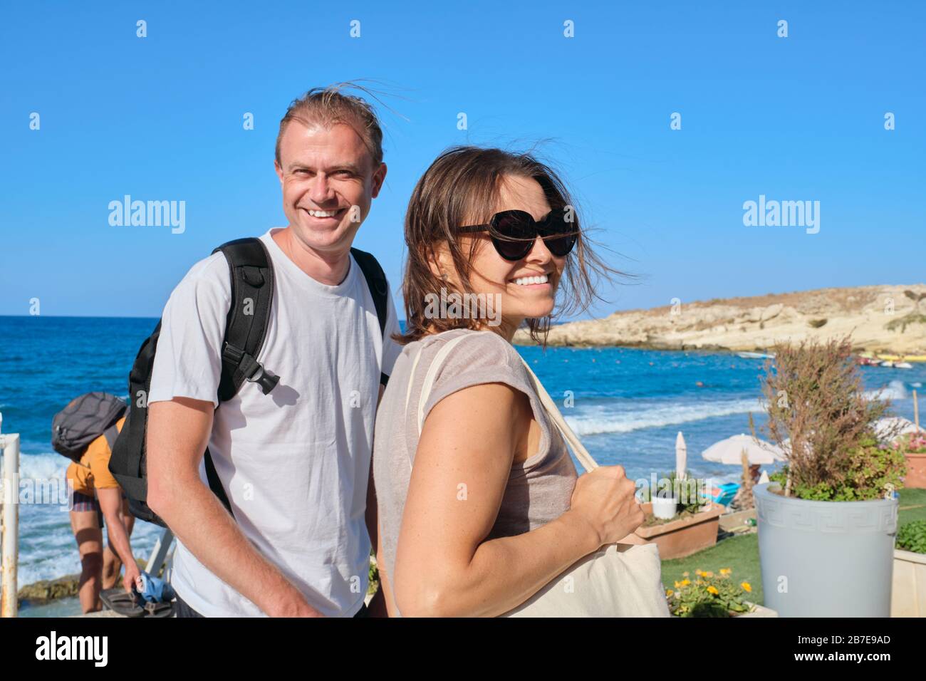 Middle-aged couple walking holding hands, man and woman traveling ...