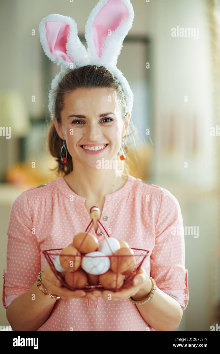 happy elegant middle age housewife in a pink blouse and easter bunny ...