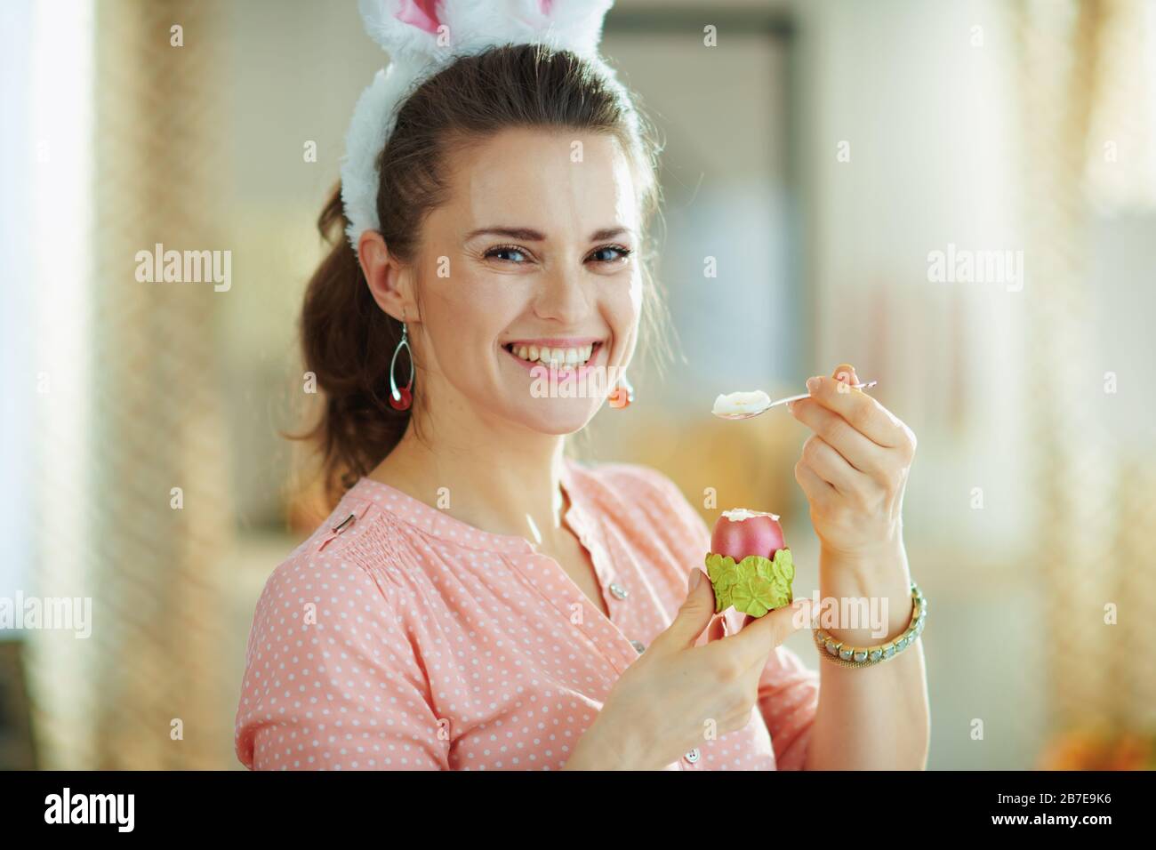 Portrait of happy modern middle age housewife in a pink blouse and ...